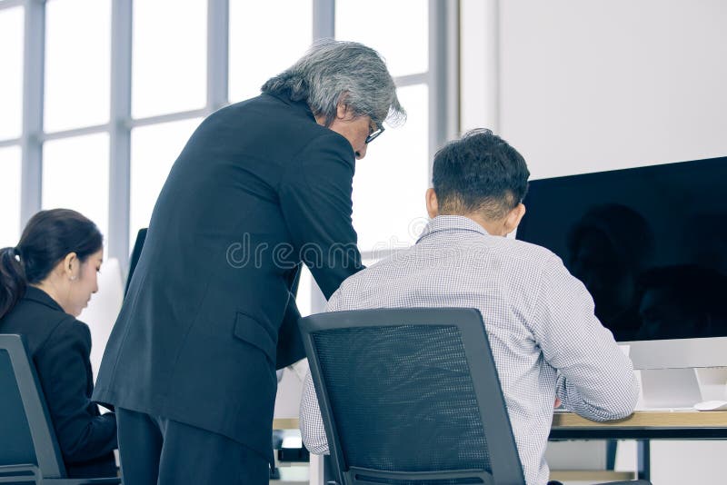 Senior Staff in Suit is Ordering a Man Employee To View a Computerized ...