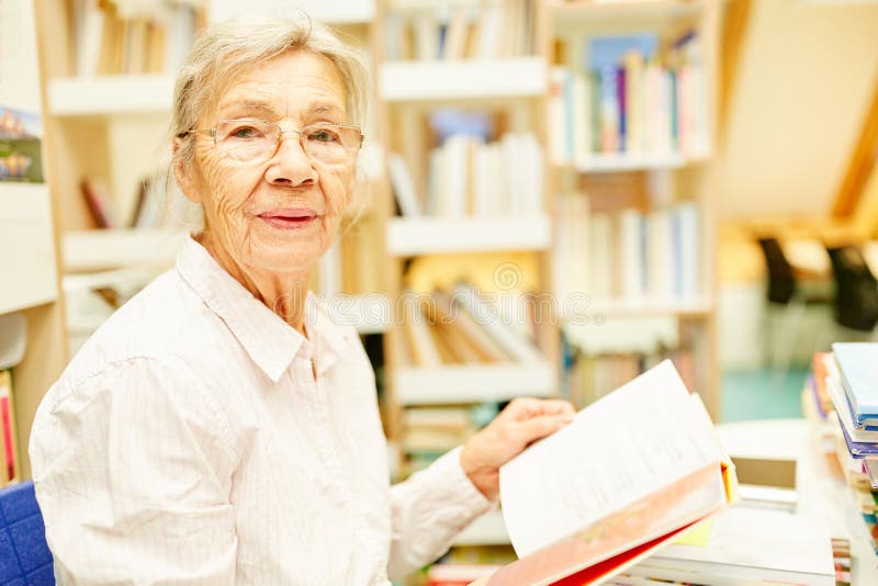 Senior Teacher or Librarian with Book Stock Photo - Image of library ...