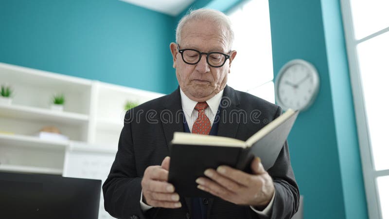 Senior Teacher Standing Reading Book at University Classroom Stock ...