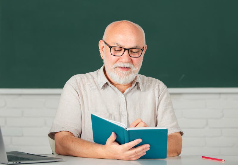 Senior Teacher Teaching in the Classroom on Chalkboard. Teacher at ...