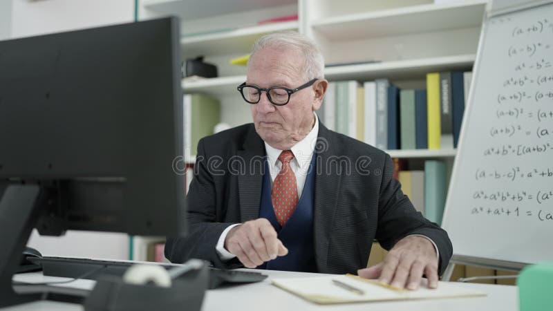 Senior Teacher Using Computer Taking Notes at University Classroom ...