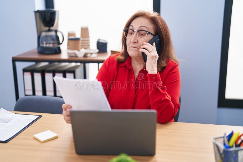 Senior Woman Business Worker Talking on Smartphone Reading Document at ...