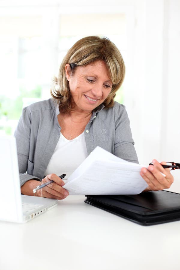 Senior Woman Doing Paperwork with Help of Internet Stock Image - Image ...