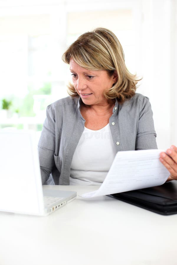 Senior Woman Doing Paperwork on Internet Stock Image - Image of ...