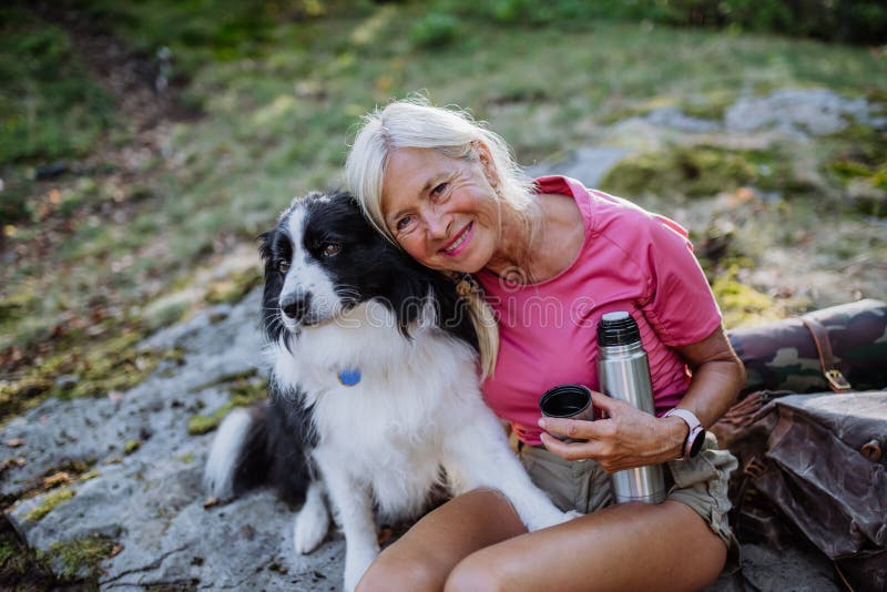 Senior Woman Having Break during Walking Her Dog in Forest. Stock Photo ...