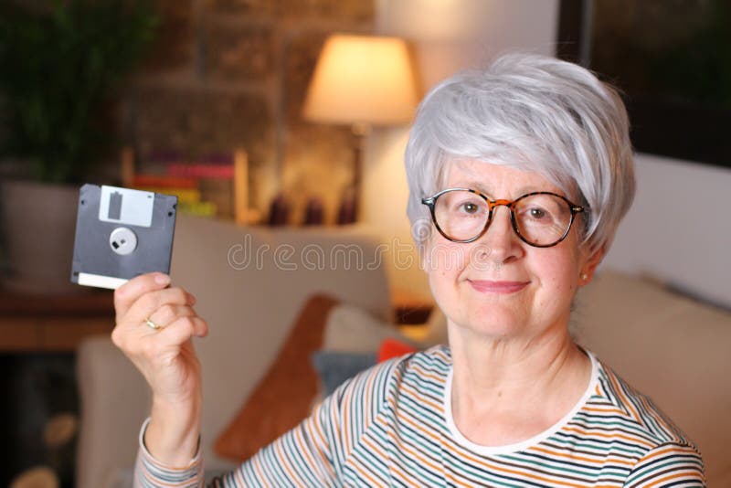 Senior Woman Holding Floppy Disk Stock Image - Image of class, adult ...