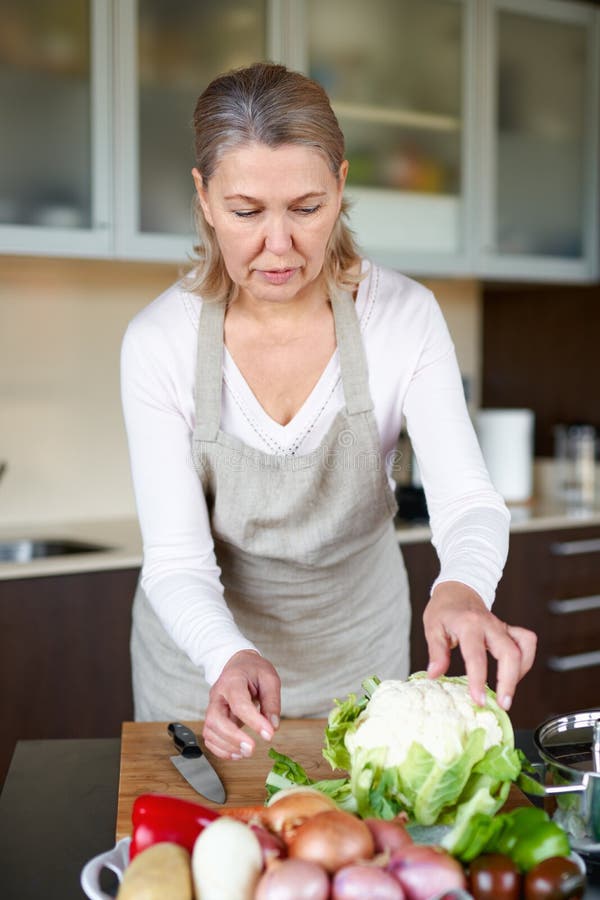 Cooking Woman Looking at Computer while Preparing Food in Kitchen ...