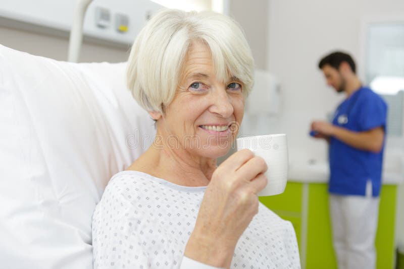 Senior Woman Lying in Bed and Drinking Tea in Hospital Stock Image ...