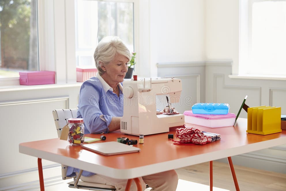 Senior Woman Making Clothes Using Sewing Machine at Home Stock Photo ...