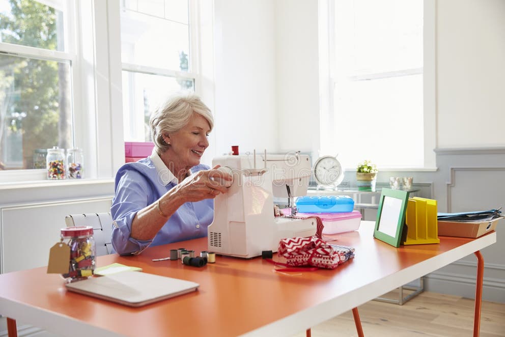 Senior Woman Making Clothes Using Sewing Machine at Home Stock Photo ...