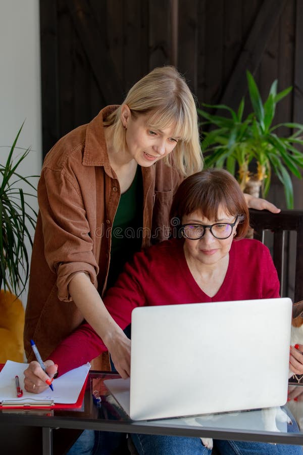 Senior Woman and Middle Age Woman Working with Laptop Computer at Home ...