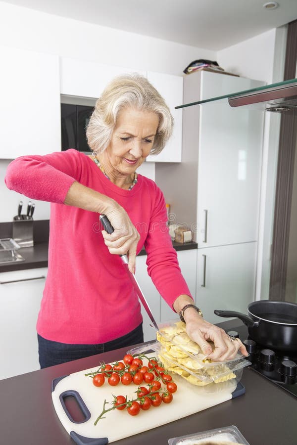Portrait of Happy Senior Woman Cooking Food at Kitchen Counter Stock ...