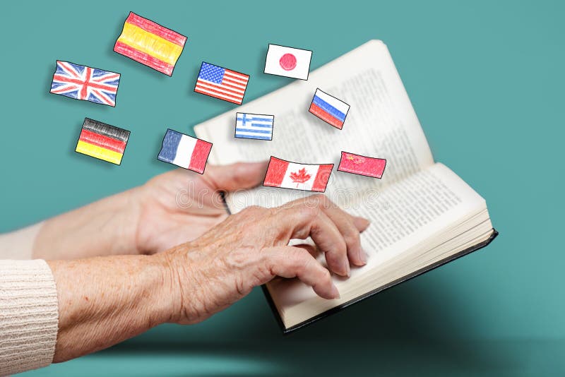A Senior Woman Reading a Book with Flags of Different Countries. Close ...