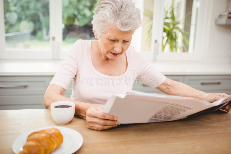 Senior Woman Reading a Newspaper Stock Photo - Image of croissant ...