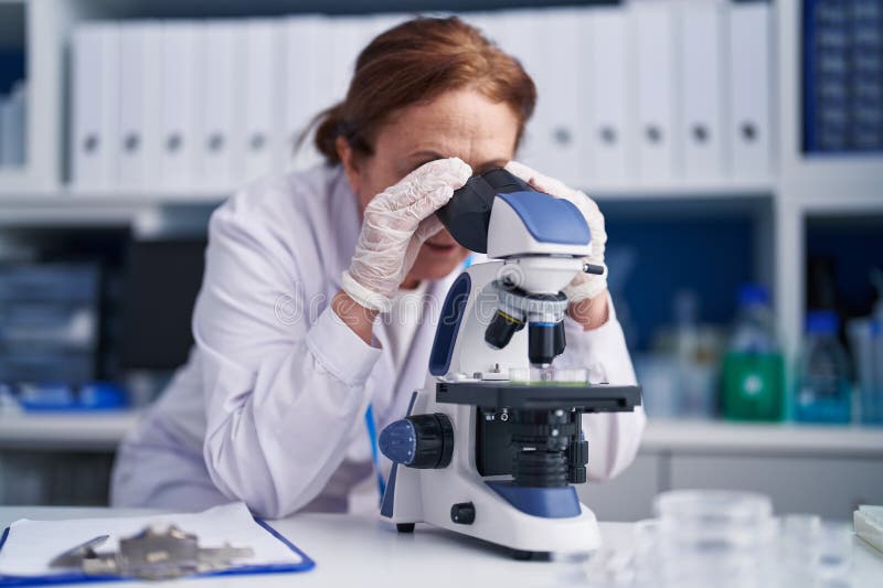 Senior Woman Scientist Using Microscope at Laboratory Stock Photo ...