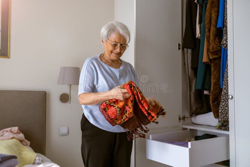 Senior Woman Sorting Out Wardrobe Stock Image - Image of kitchen ...