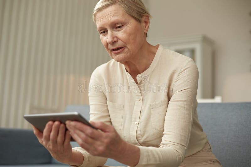 Senior Woman Using Digital Tablet at Home. the Use of Technology by the ...