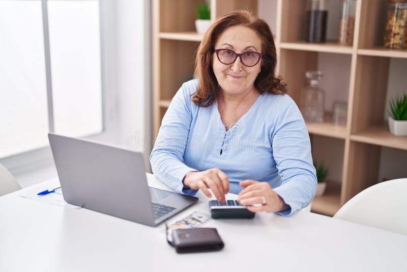 Senior Woman Using Laptop and Calculator at Home Stock Image - Image of ...
