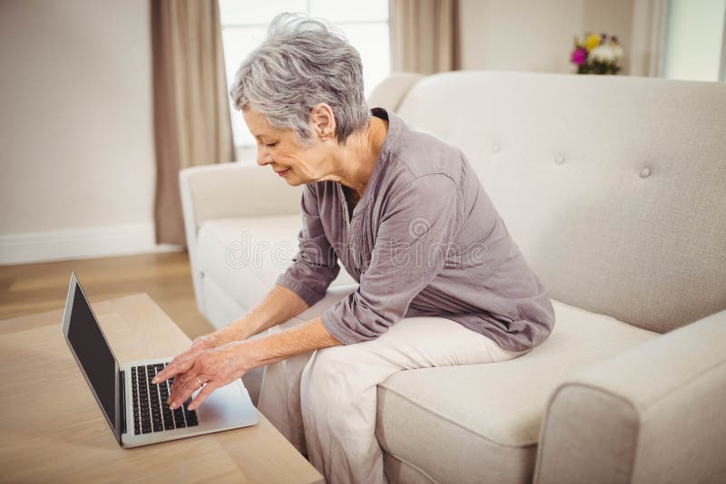 Senior Woman Using Laptop in Living Room Stock Image - Image of laptop ...