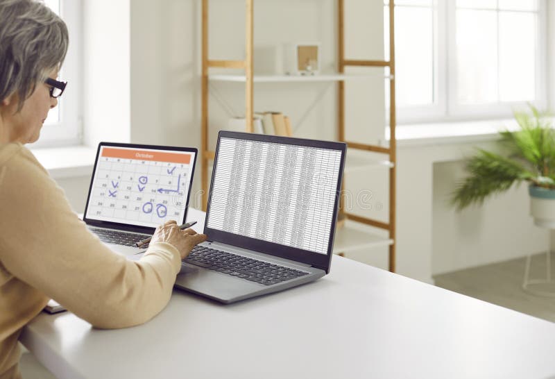 Senior Woman Using Spreadsheets and Calendar App on Laptop To Plan Work ...