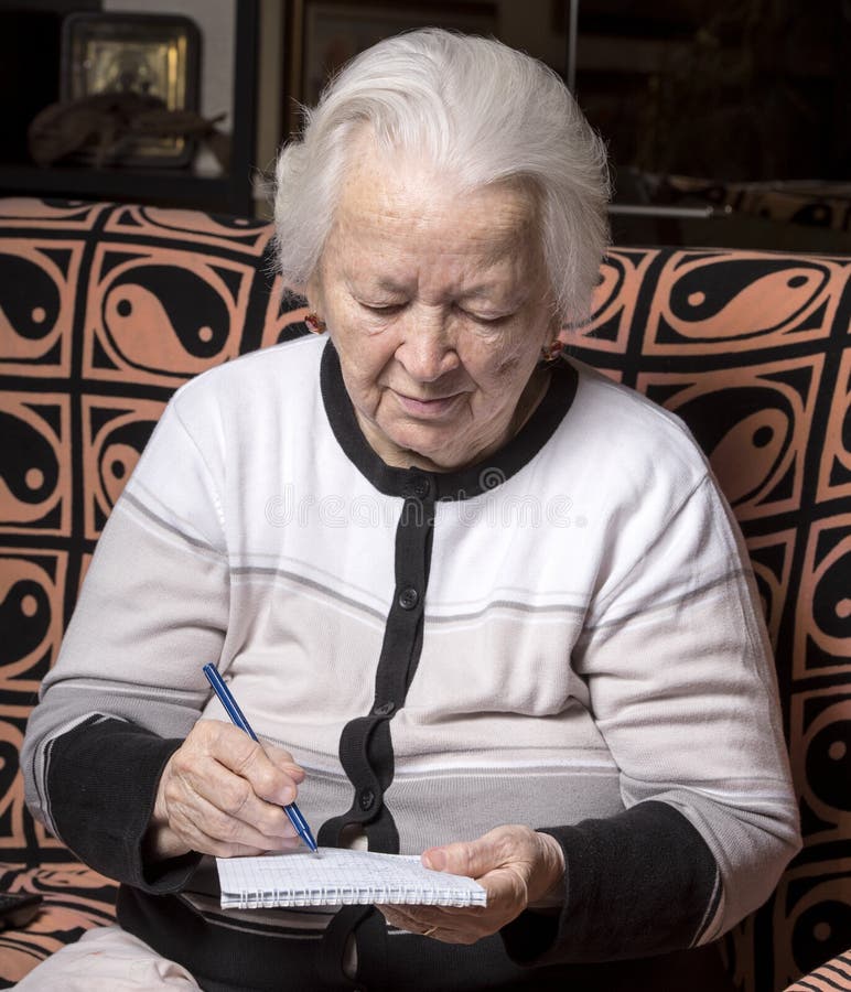 Senior woman writing notes stock image. Image of indoors - 49774885