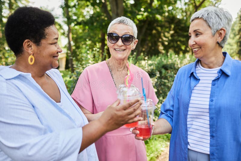 Senior Women Enjoying Drinks Outdoors in Park Stock Photo - Image of ...