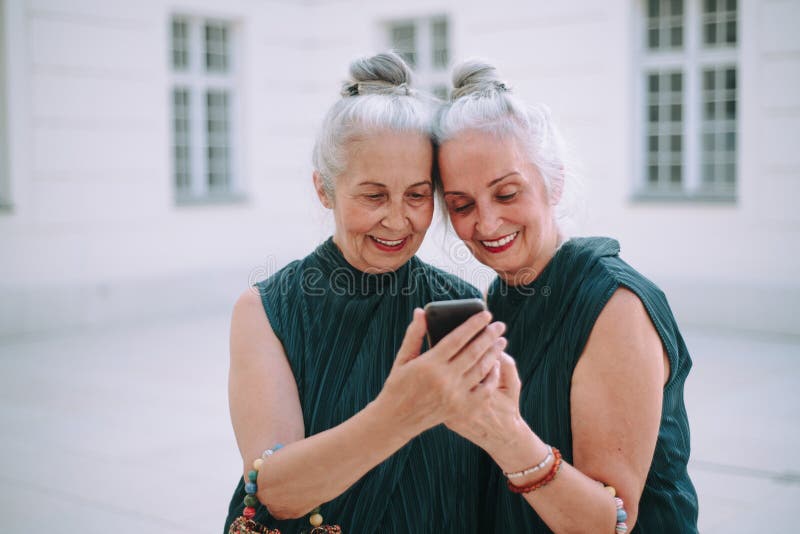 Senior Women Twins Outdoors in City Checking Smartphone. Stock Image ...