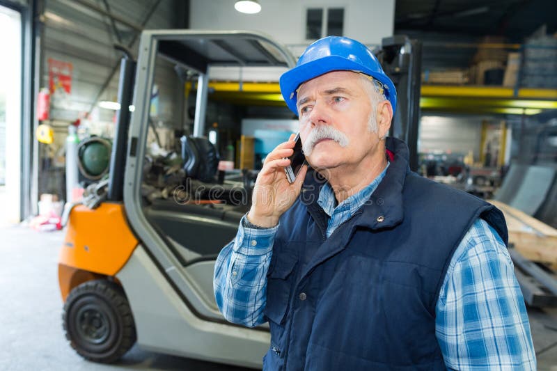 Senior Worker by Forklift Talking on Mobile Phone Stock Image - Image ...