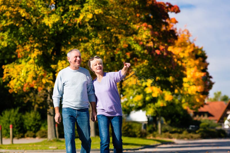Senior Couple Walking through Autumn Woodland Stock Photo - Image of ...