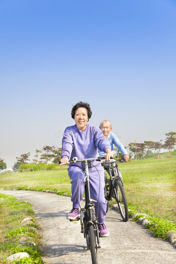 Seniors Couple Biking in the Park Stock Image - Image of outdoors ...