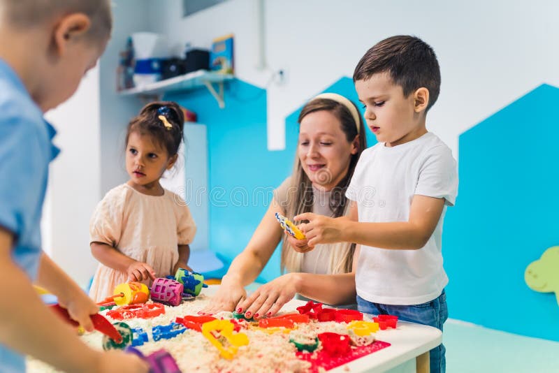Sensory Play at Nursery School. Toddlers with Their Teacher Having Fun ...