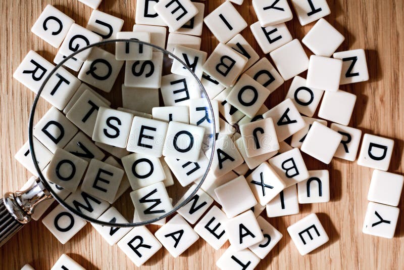 SEO Concept with Magnifying Glass Over SEO Text Spelled Out from Mixed ...
