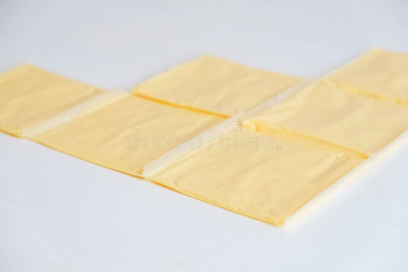 Separately Packed Cheese Slices on a White Wooden Table Background ...