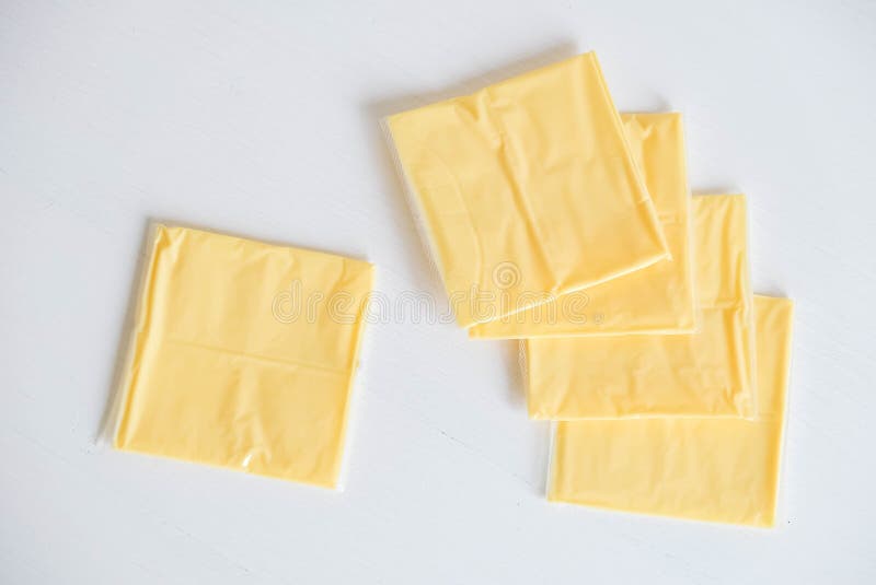 Separately Packed Cheese Slices on a White Wooden Table Background ...