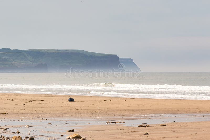 Serene Beach with Distant Cliffs and Gentle Waves in Whitby, North ...