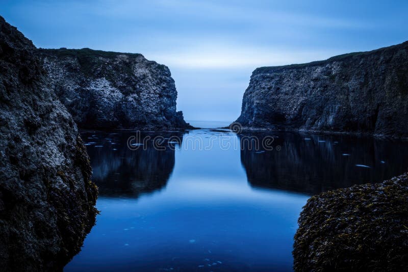 Serene Coastal Cliffs and Calm Blue Ocean Reflecting Twilight Sky Stock ...