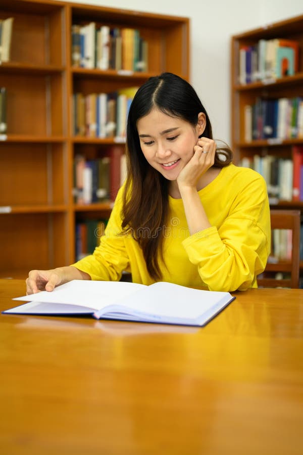 Serene Female Student Reading Book in a Library for Studying and ...