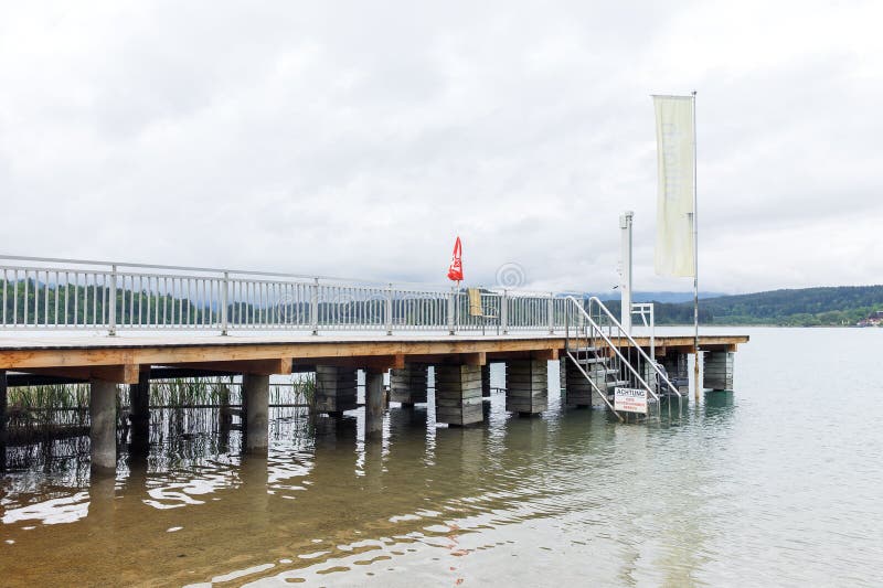 Serene Lakeside Pier with Overcast Sky and Calm Waters Editorial ...