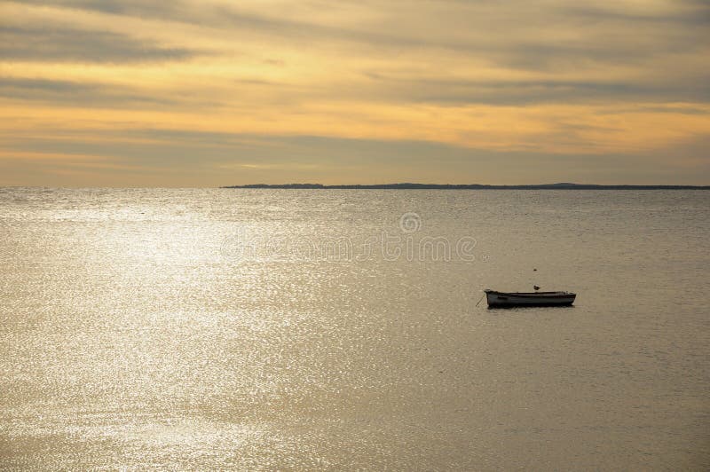 Serene Ocean View with Lone Boat at Sunset in Piriapolis, Uruguay Stock ...
