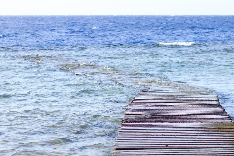 Serene Old Wooden Dock Extending into Tranquil Blue Ocean Water Stock ...