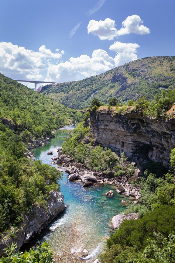 A Serene River Flows through a Dramatic Canyon, Surrounded by Lush ...