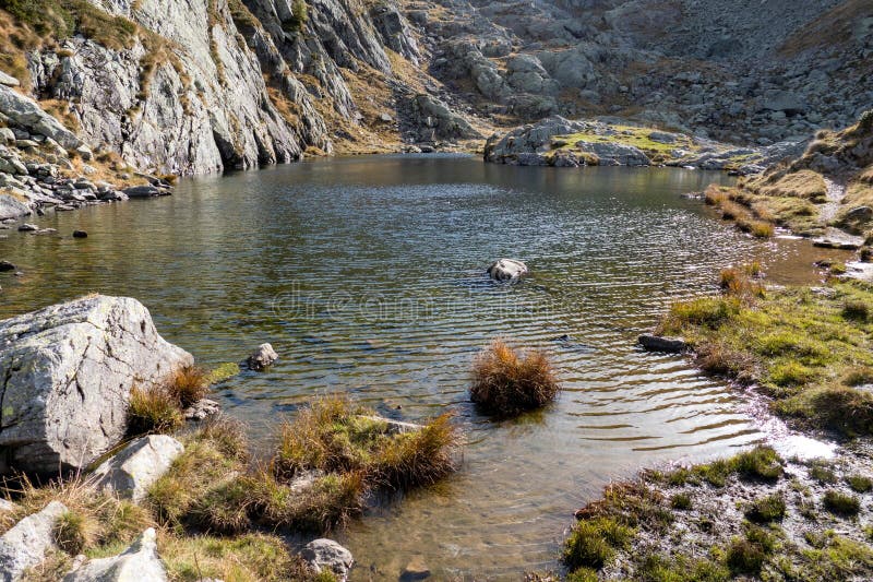 Serene River Surrounded by Rocky Terrain Stock Photo - Image of ...