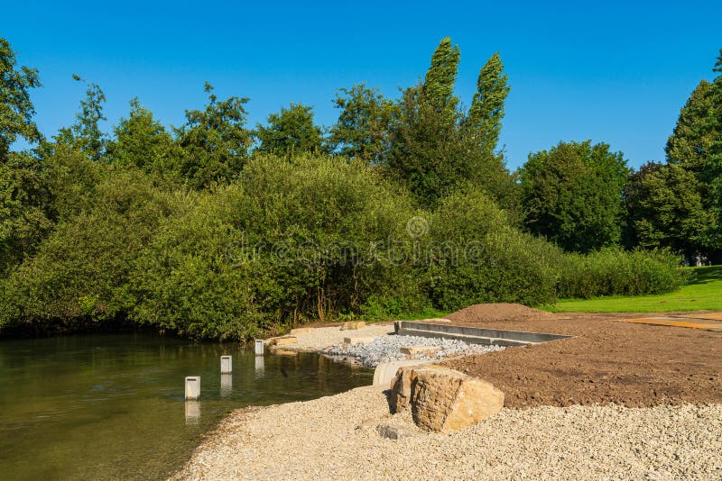 Tranquil Riverside Landscape with Lush Greenery, Blue Sky, and a Sandy ...