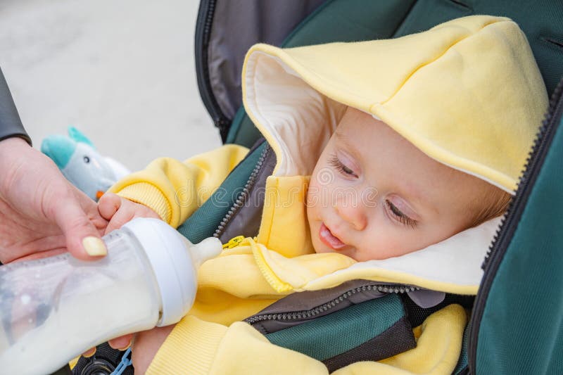 Serene Scene of Mother Feeding Her Baby in a Pram. Stock Image - Image ...