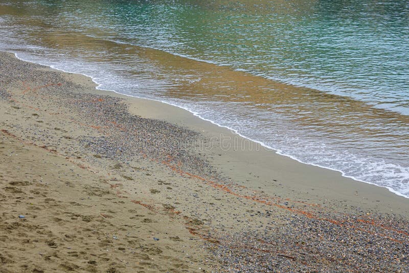 A Serene Shoreline Features a Mix of Sand and Pebbles with Gentle Waves ...