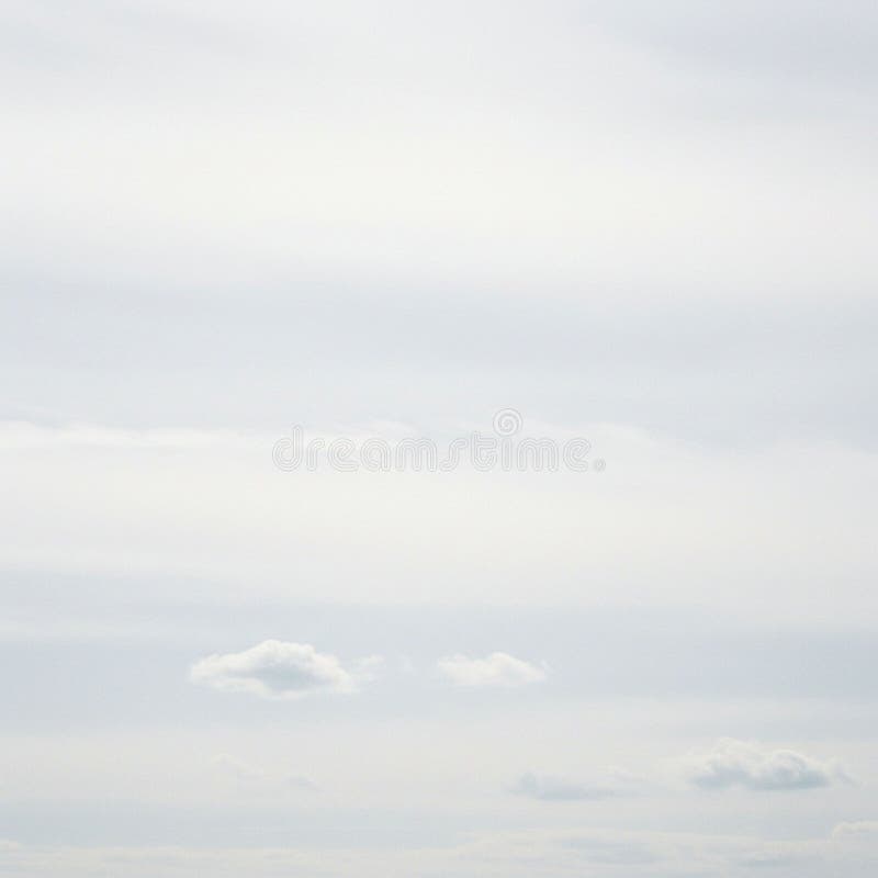 A Serene Sky with Soft, Wispy Clouds Scattered Across a Light Gray ...