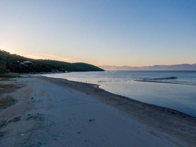 Serene Sunset Beach View with Calm Waters and a Distant Hillside Stock ...