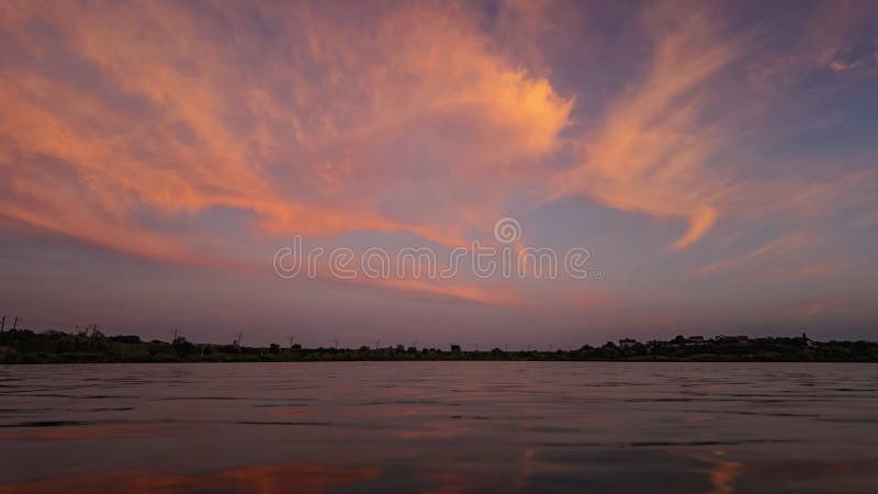 A Serene Sunset Over a Tranquil Lake with Rippled Water, Sky with Soft ...