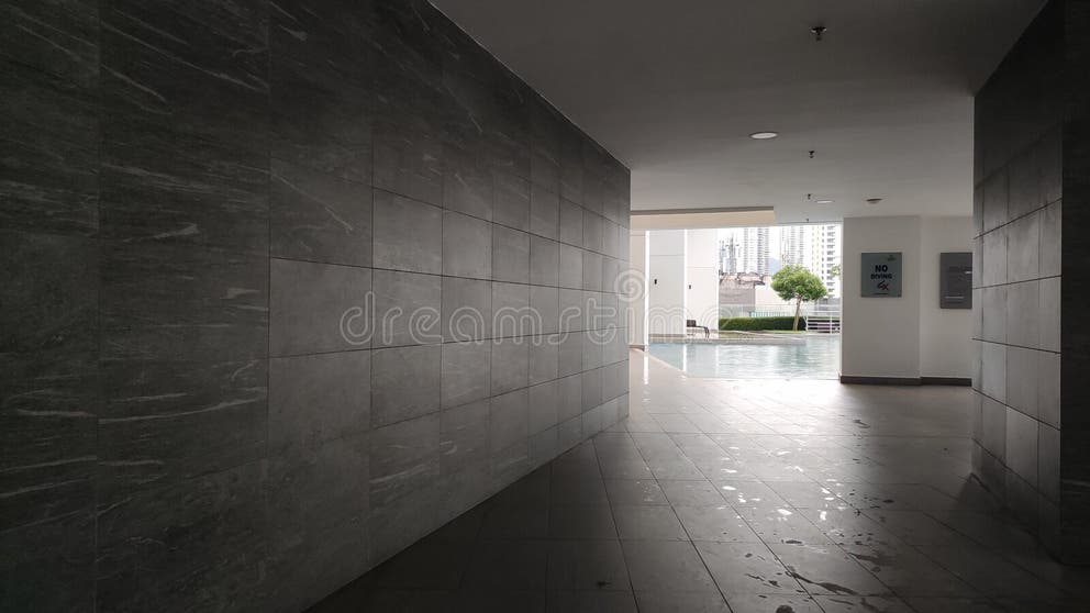 A Serene View of a Corridor with Concrete Tiles Pattern on the Wall ...