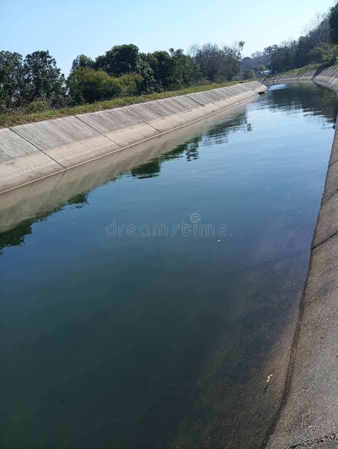 Serene Water Canal with Reflections of Trees and Sky Stock Image ...